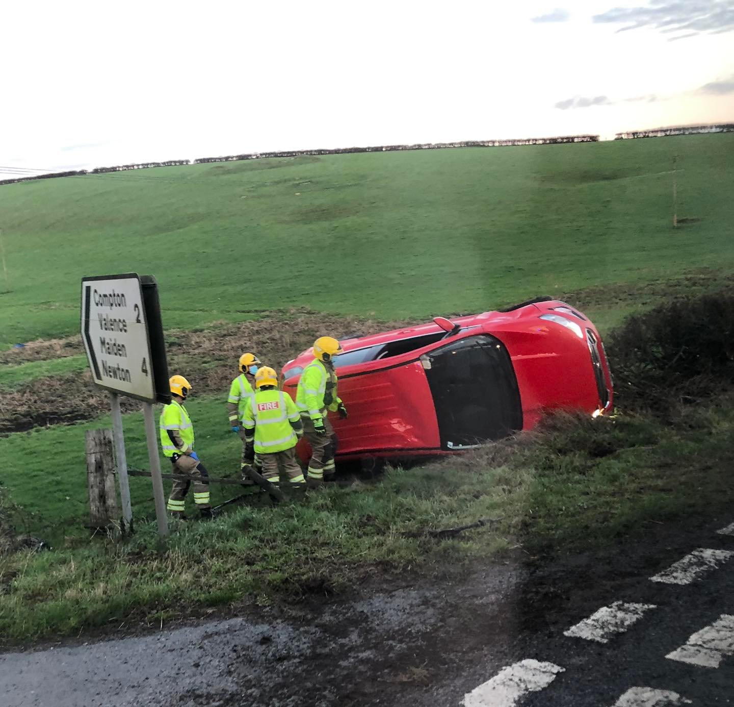 Car ends up on its side in a field after A35 crash