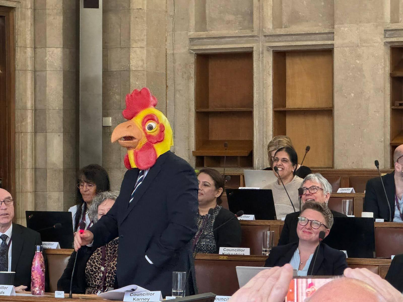 Bizarre moment Pat Karney dons a chicken mask during a council meeting