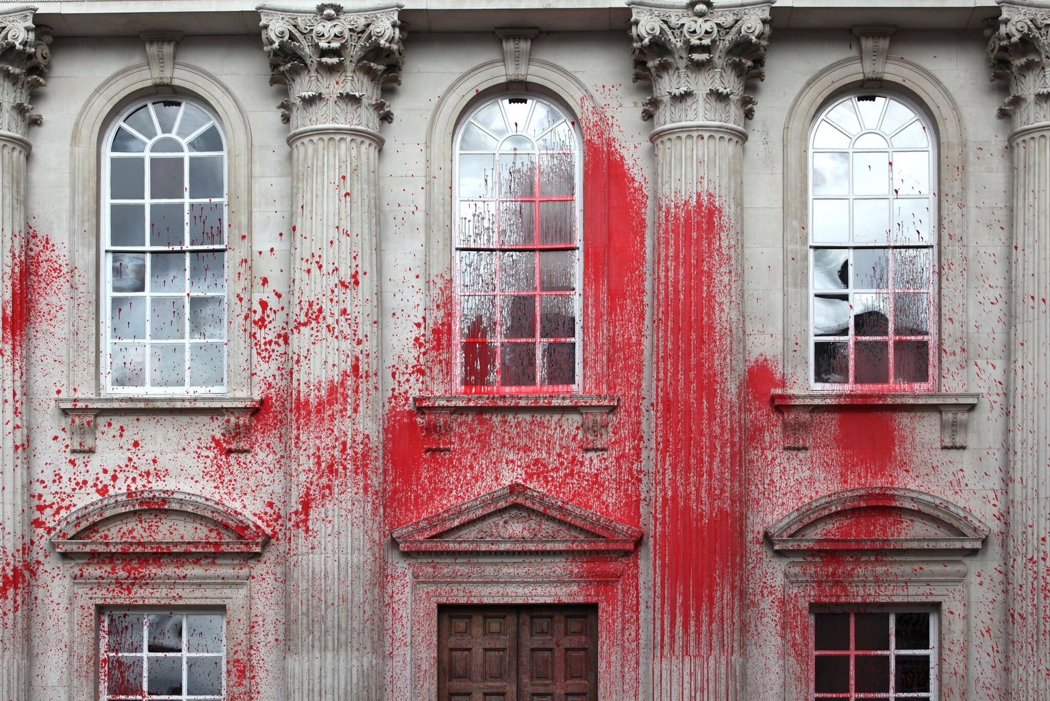 Protestors throw red paint over Cambridge University building